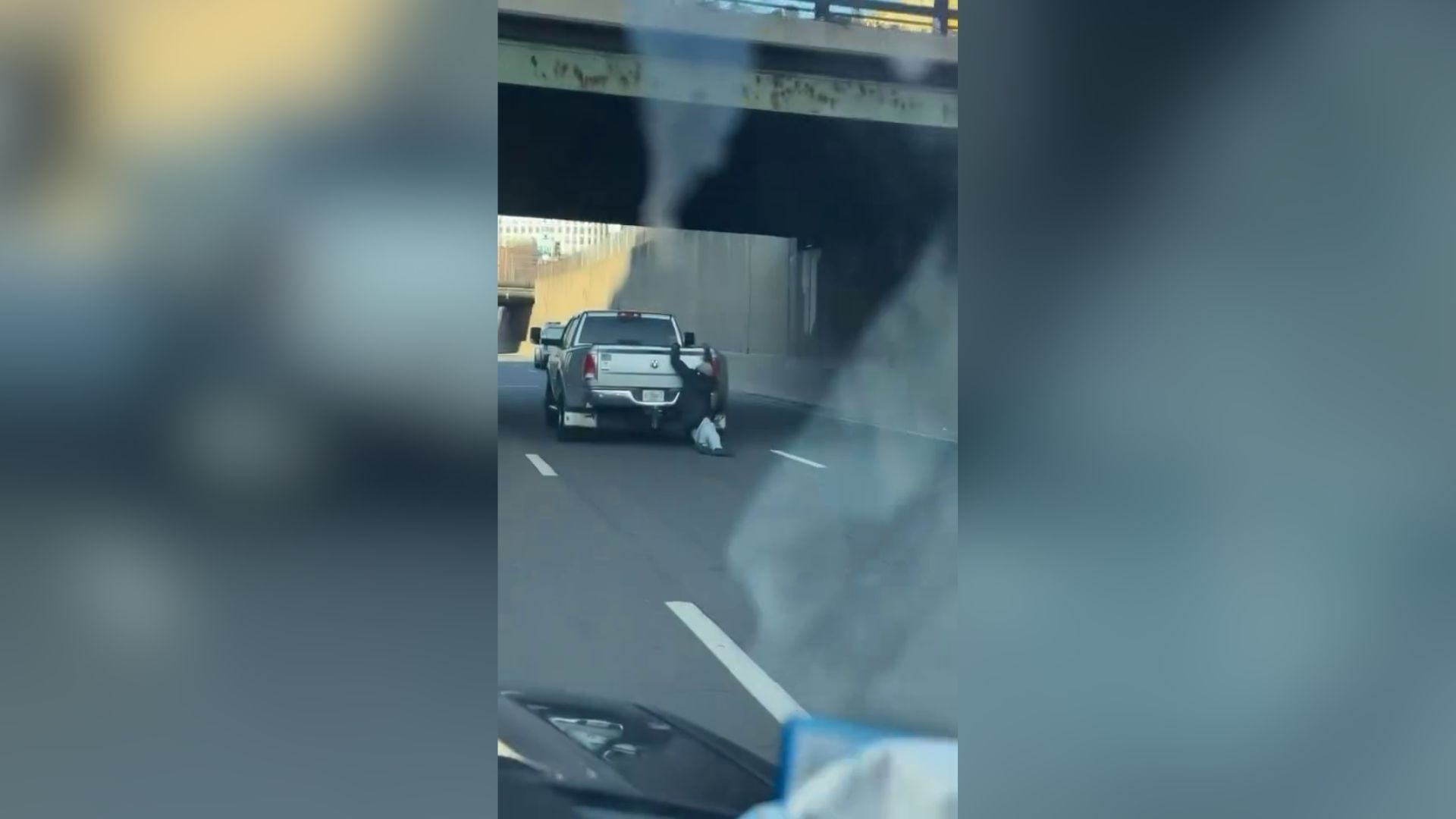 Watch: Man clings to back of pickup truck on Mass Pike
