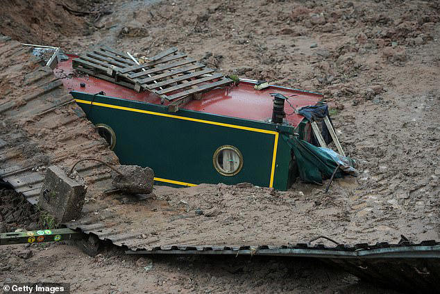 Deserted narrowboats are still stuck in the mud of drained canal weeks ...