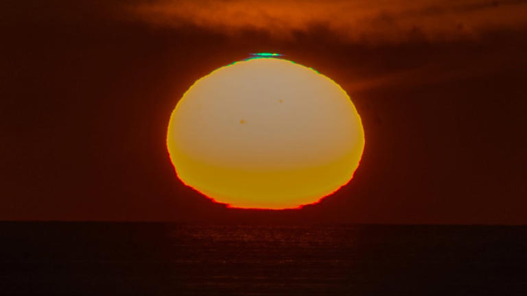 What is a 'green flash' and why does it happen?