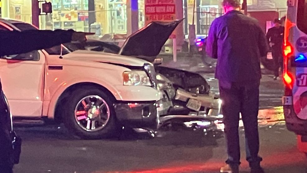 Two injured as car runs red light and collides with truck, police say