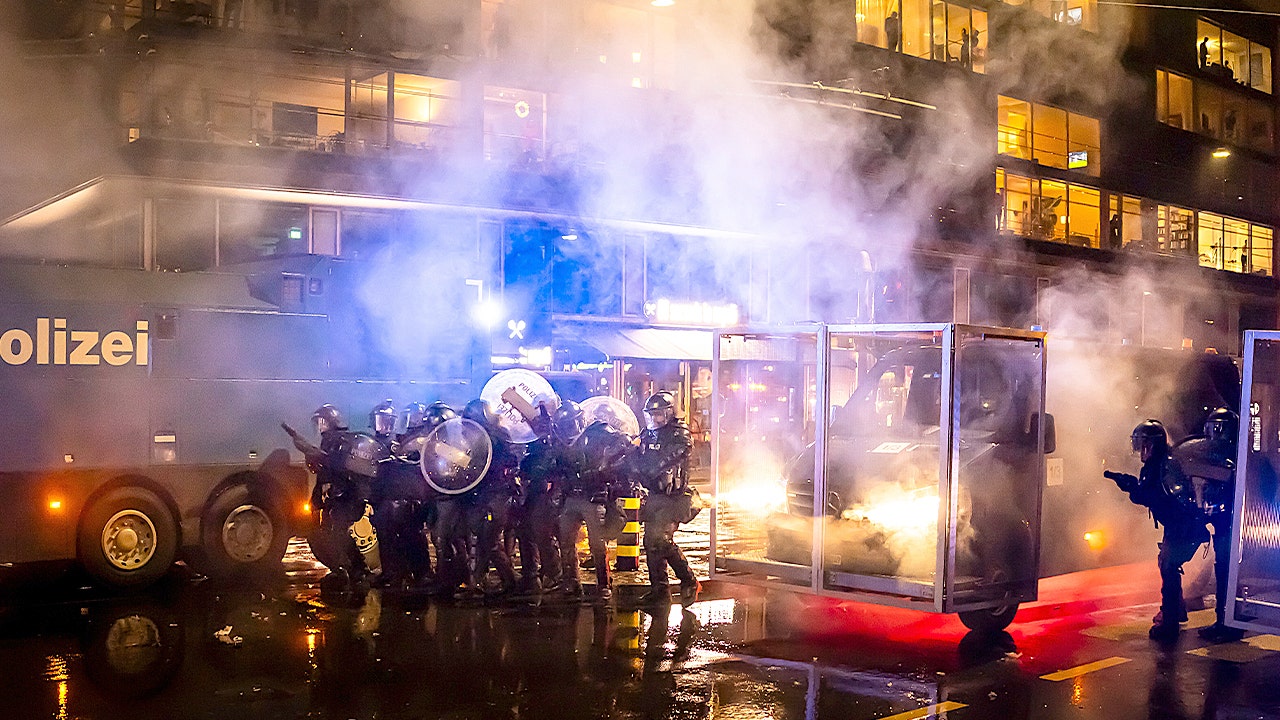 American flags torched, riot police clash with protesters ahead of ...