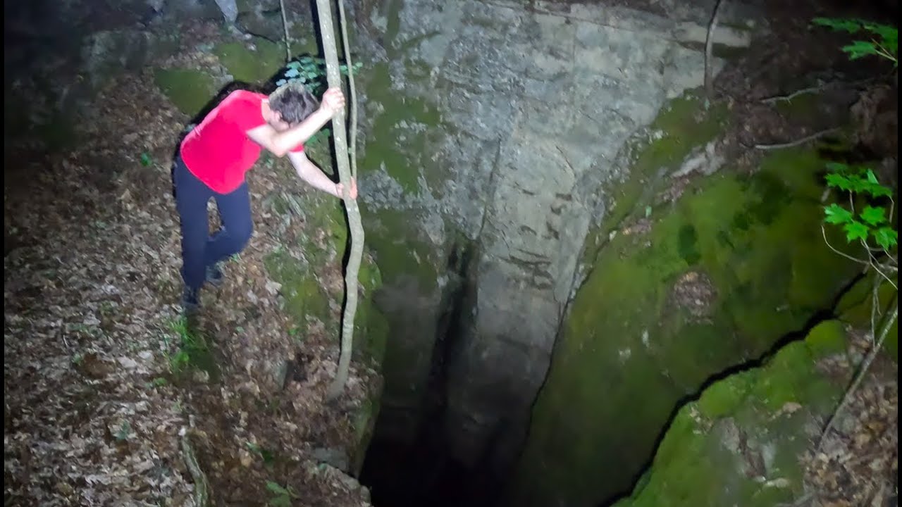 Train tracks collapsed into a hole leading to a hidden lake below