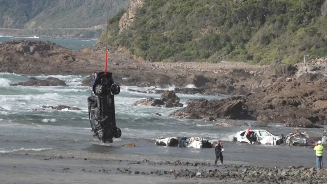 Mangled cars winched by helicopter as flood clean-up continues