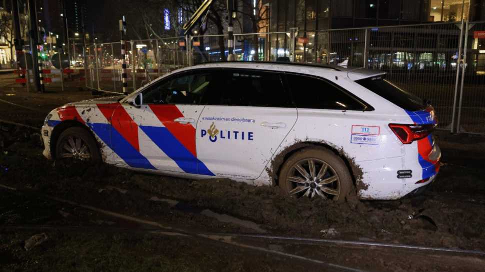 Snelle Audi A6-politieauto komt muurvast te staan in modderig Rotterdam