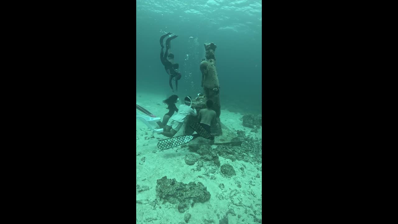 Divers pose next to sunken Child Jesus statue in Philippines