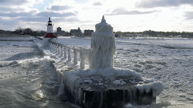 Massive waves crash over ice-covered Michigan lighthouse