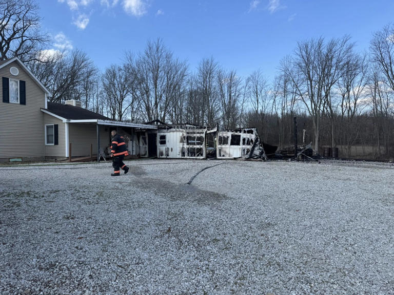 Firefighters halt garage fire from spreading to house