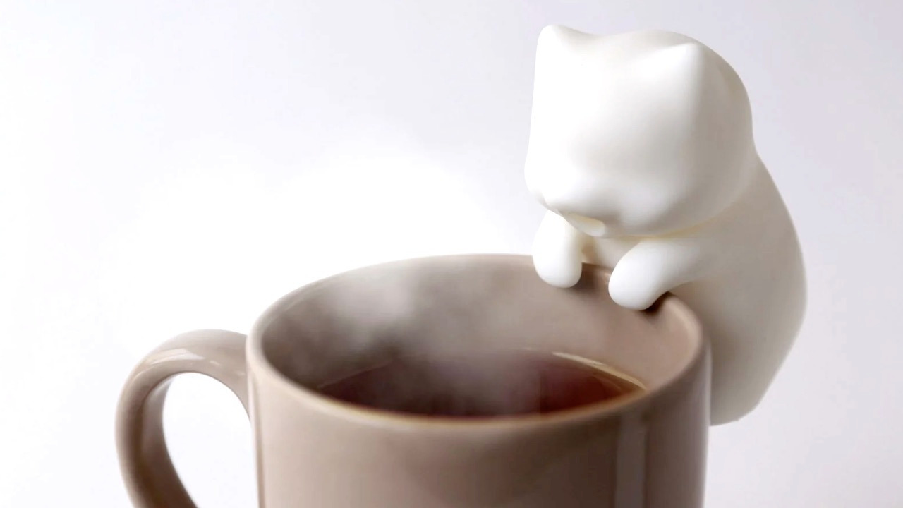 This mini cat robot perches on your mug to cool down your drink