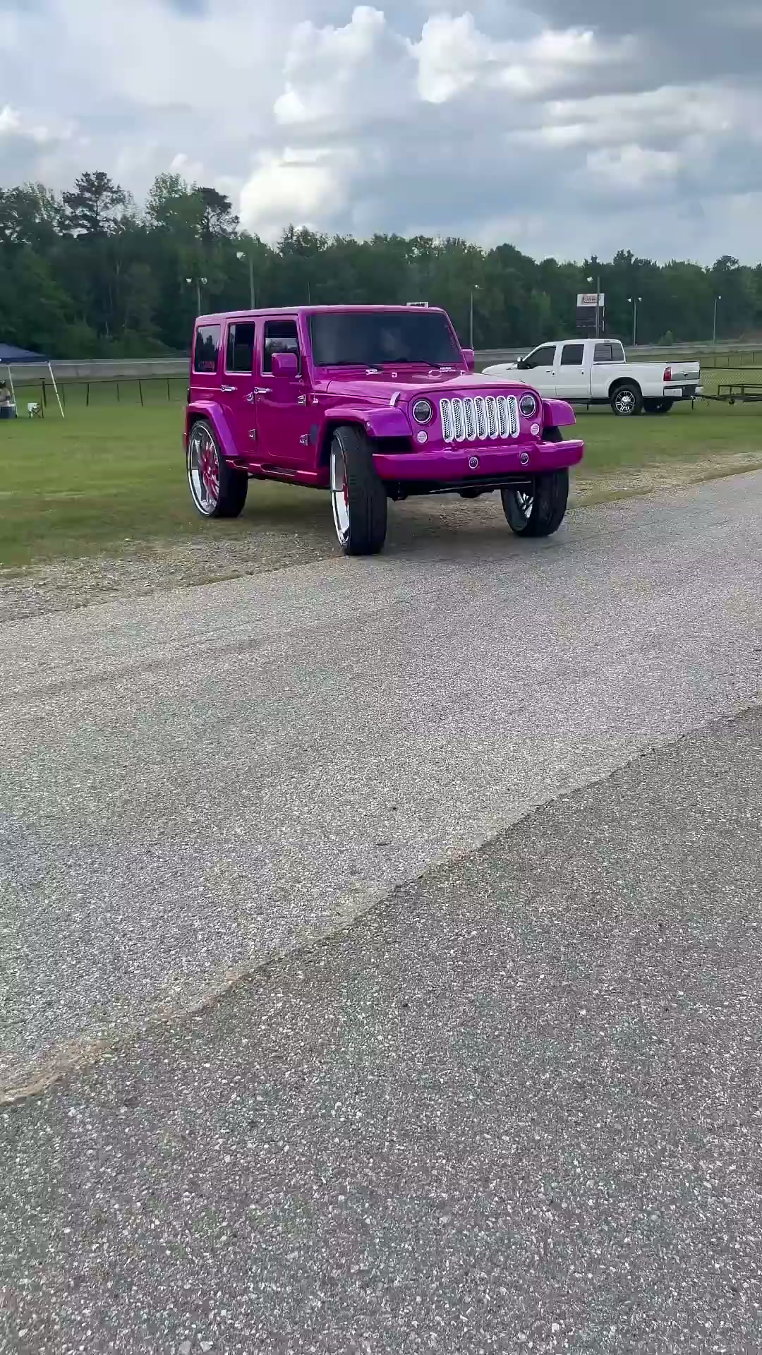 Candy magenta Jeep Wrangler on 32’s riding at the carshow