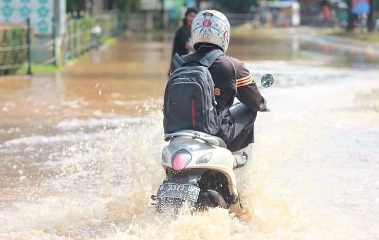 Inilah batas aman trabas banjir pakai motor matic. Jangan asal nyemplung!