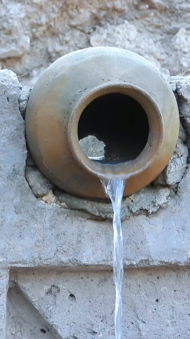 A man, likely the creator of this artistic village, sits near a house ...