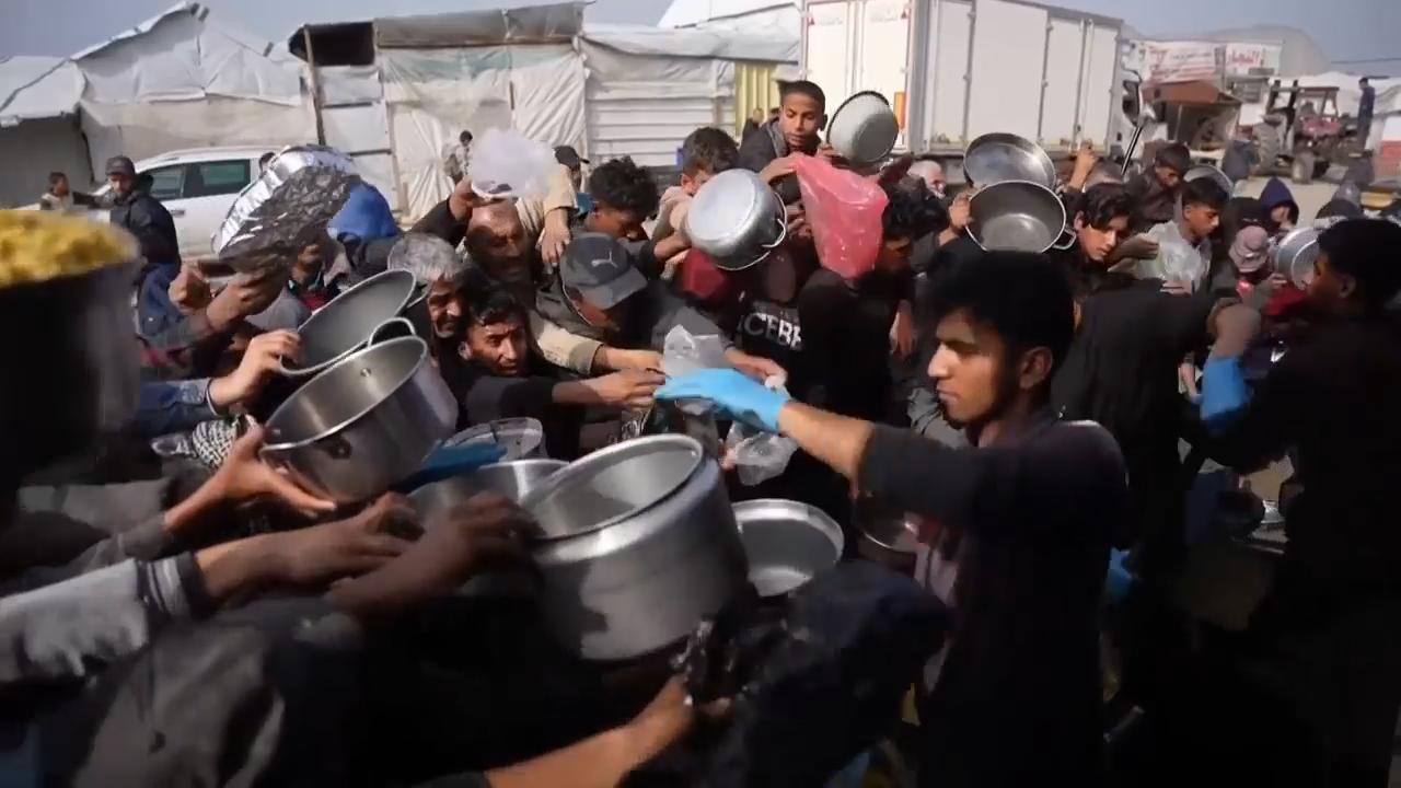 Gaza displaced line up at an Al-Muwasi field kitchen amid food ...