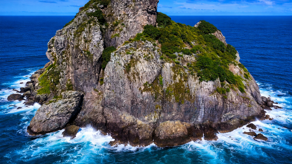 Rocky island surrounded by deep blue sea