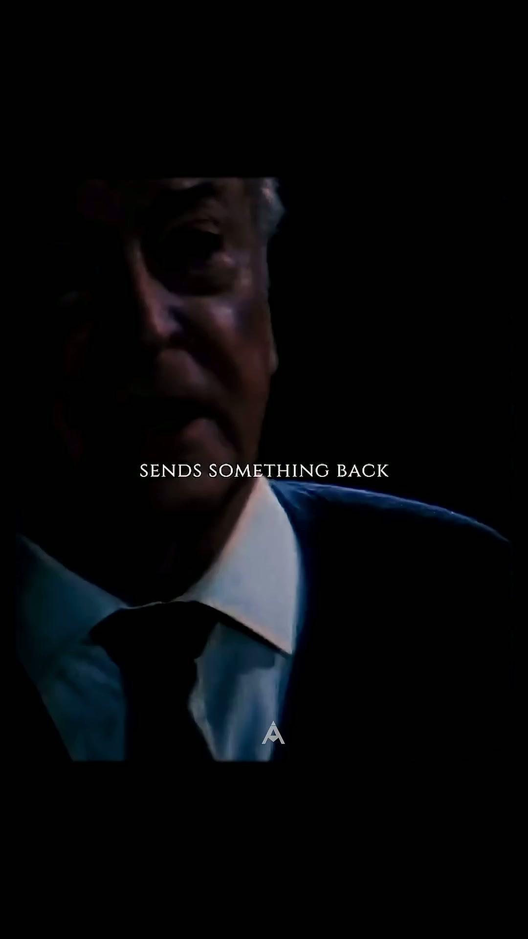 A man rises from the darkness