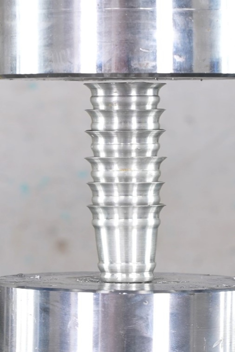 Metal cup stack under hydraulic press