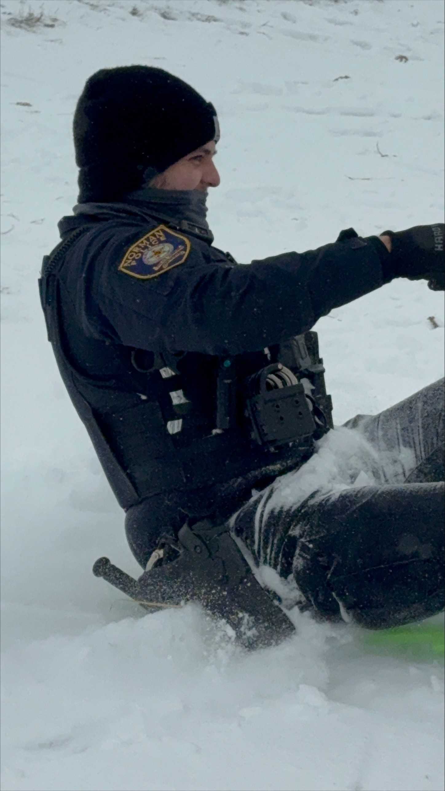Police officers grab sleds and join Norman children for snow day fun