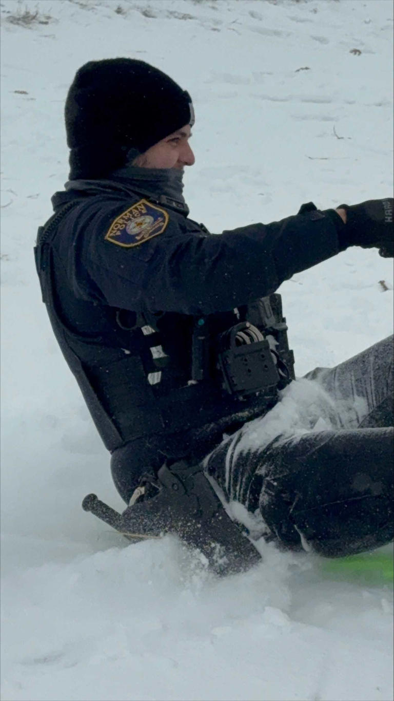 Police officers grab sleds and join Norman children for snow day fun