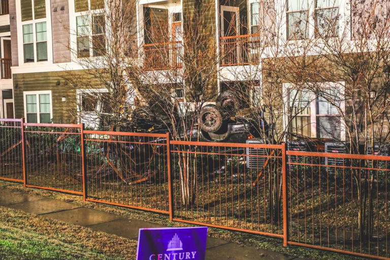 Driver hospitalized after rollover and crash into apartment building