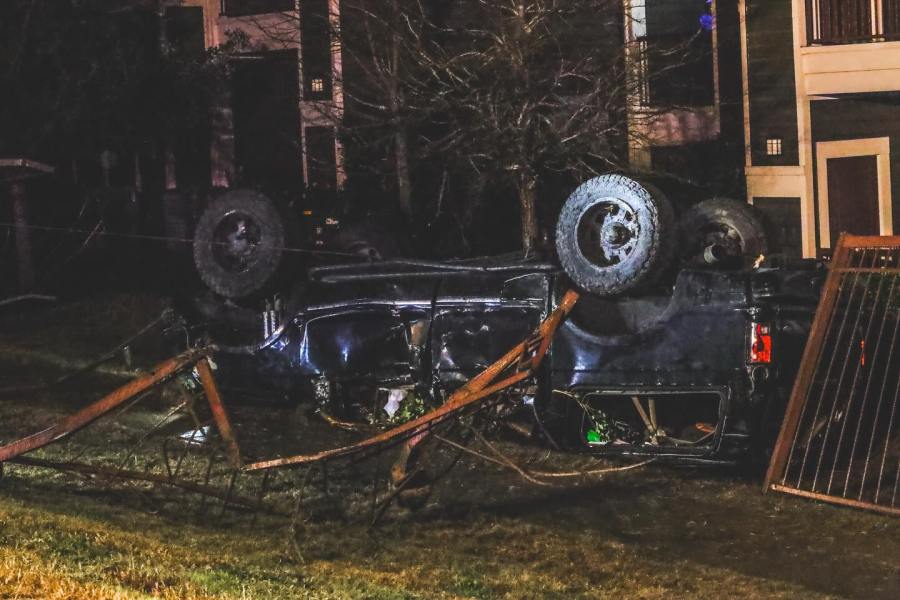 Driver hospitalized after rollover and crash into apartment building
