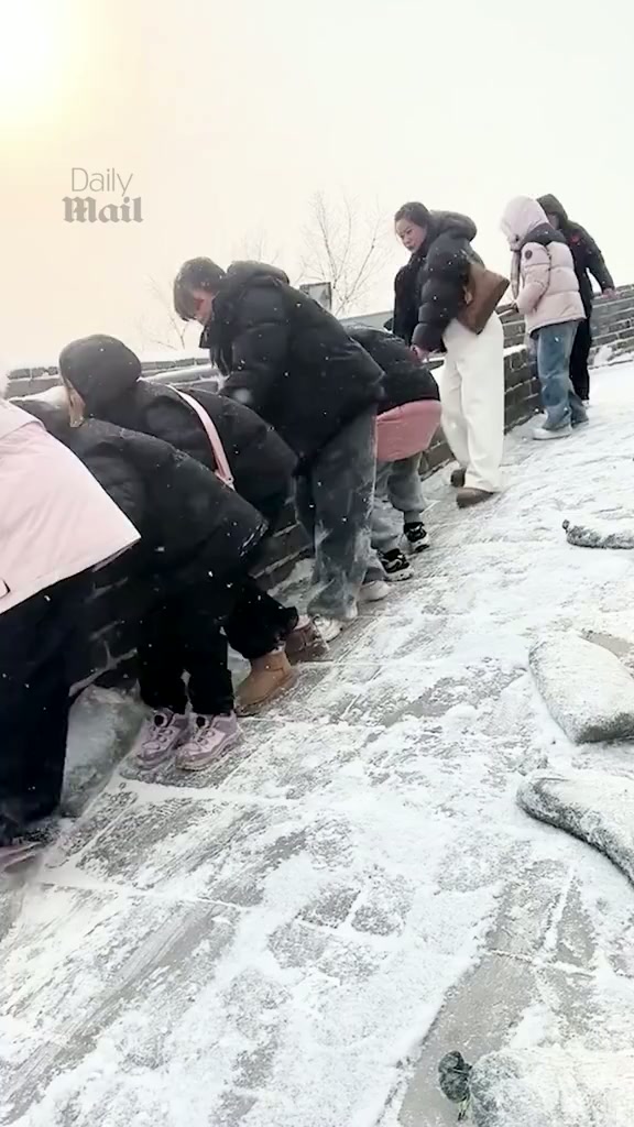 Tourists slip and slide on snow-covered Great Wall of China