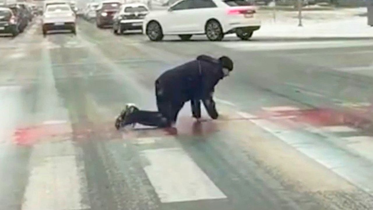 Slippery streets force man to crawl across crosswalk