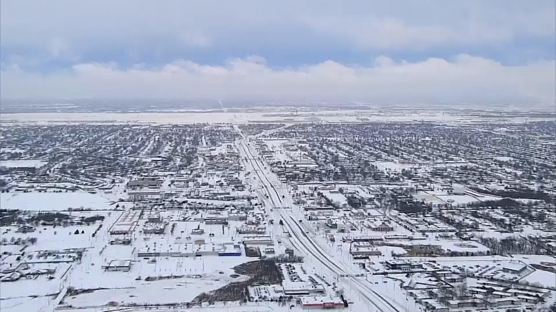 Aerial footage shows a snow-covered Oklahoma City, snow plows at work