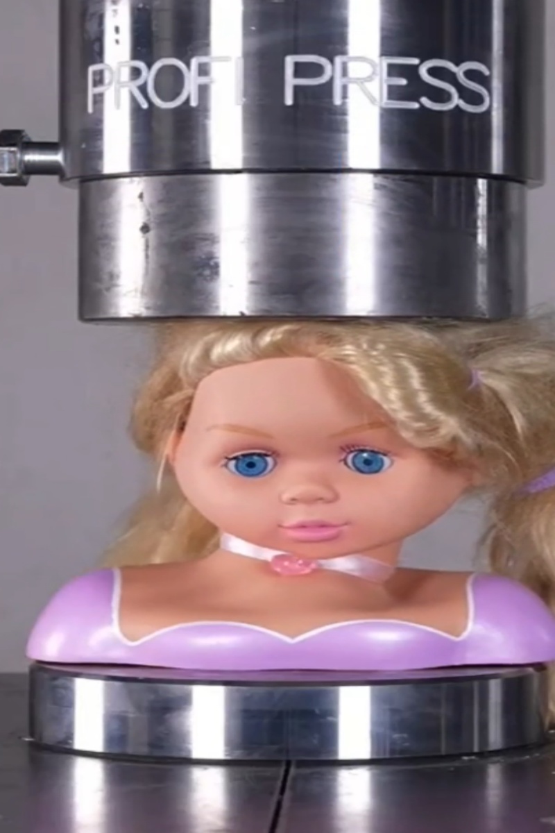 Głowa lalki pod prasą hydrauliczną