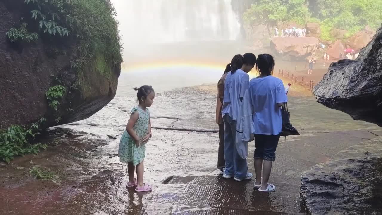 Toddler slips on wet rocks and slides dangerously towards waterfall