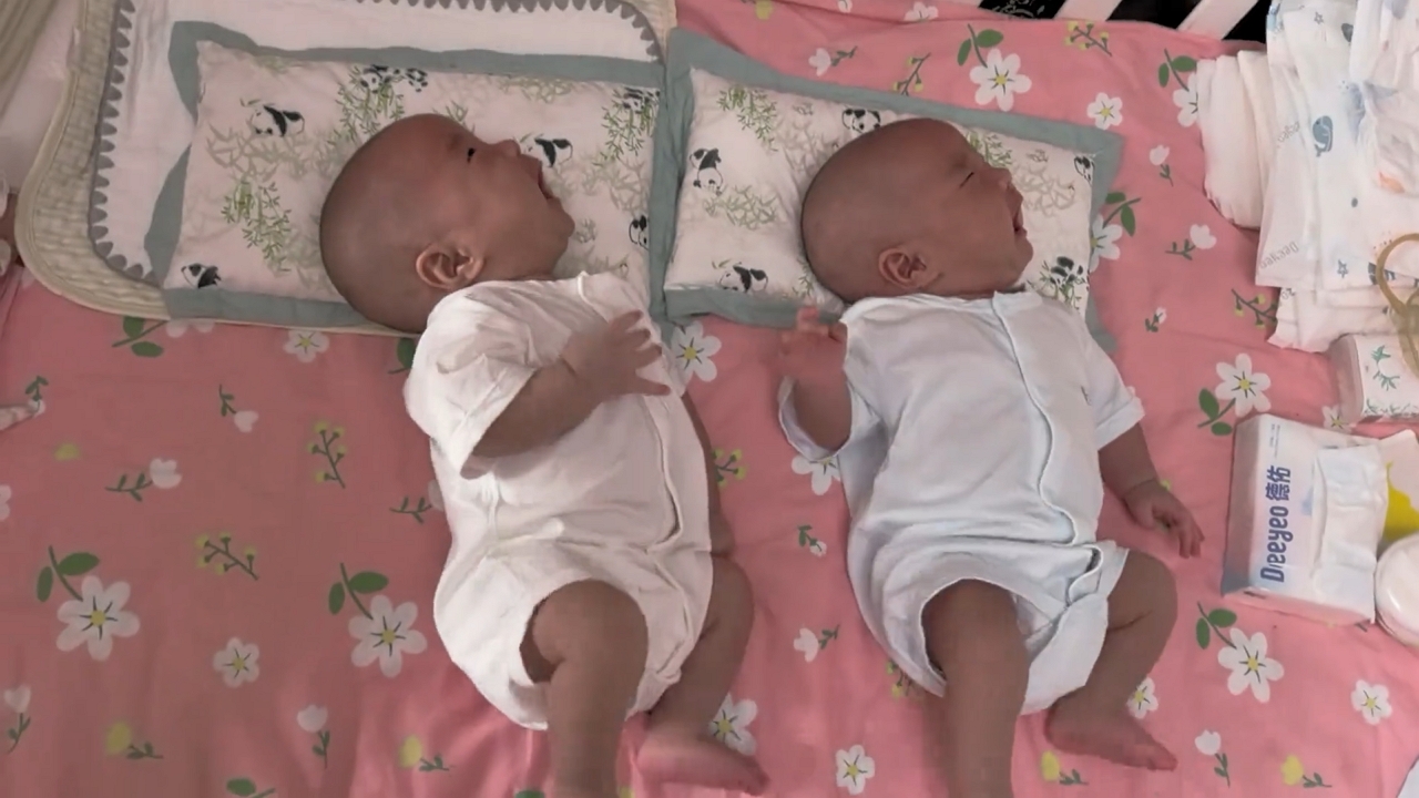 Adorable newborn twins cry together on a mattress in Jilin, China