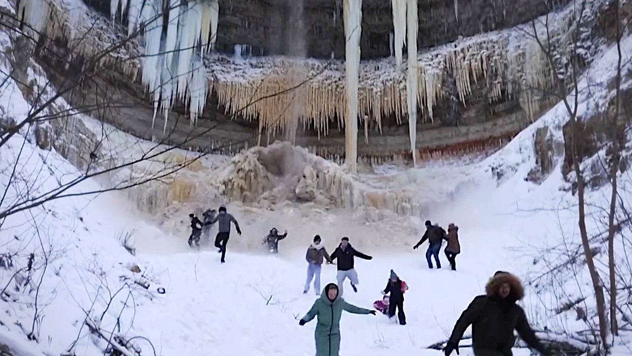 Frozen waterfall collapses as huge icicles crash down near families