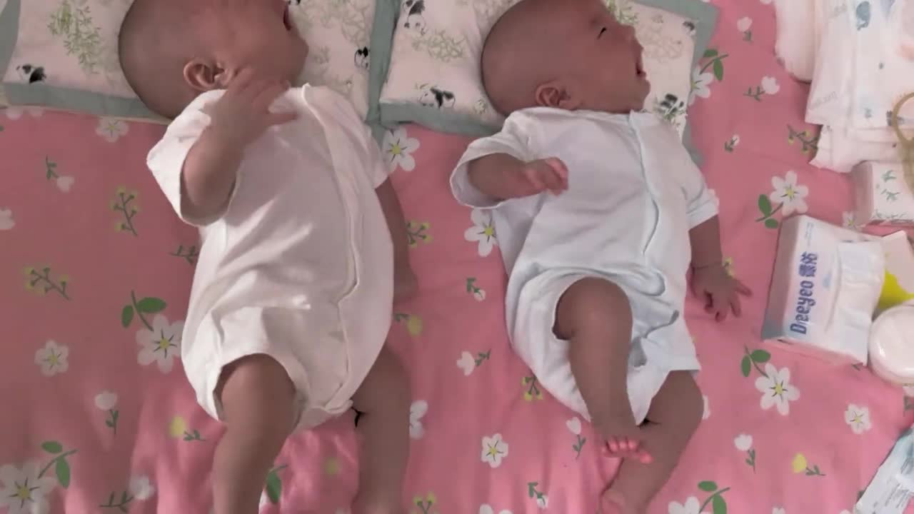 Adorable newborn twins cry together on a mattress in Jilin, China