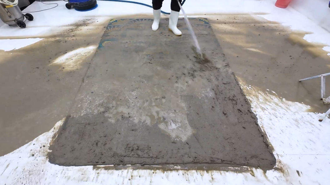 Heavy mud rinsed from a large carpet