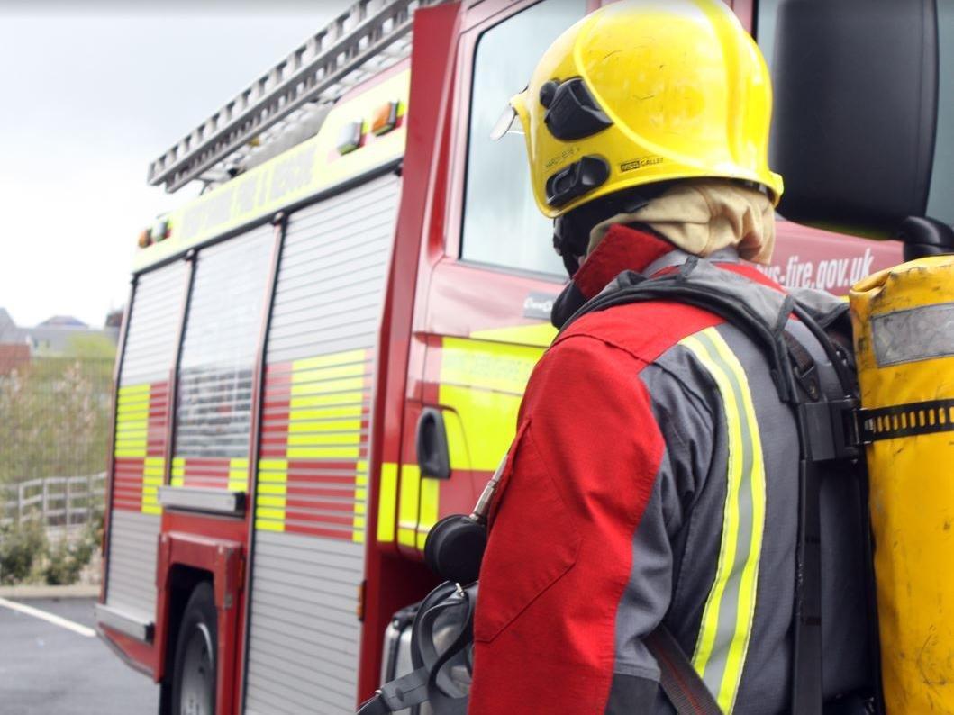 Wigan firefighters use a chain of buckets to put out a car blaze at an ...