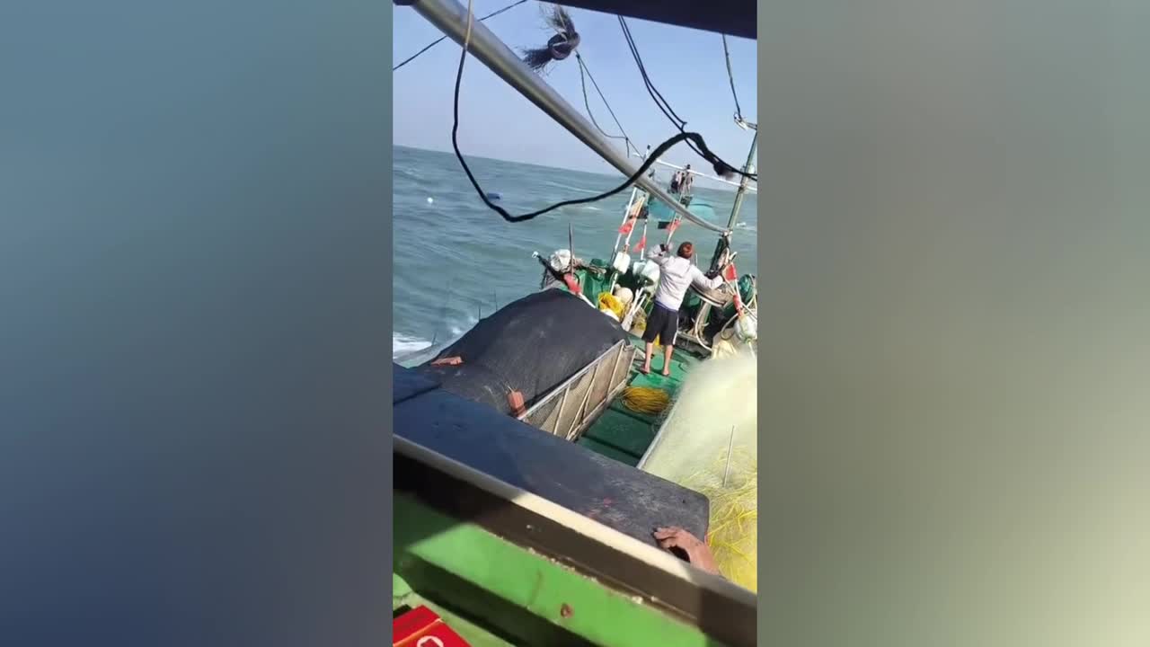 Fishermen stand on overturned boat in desperate sea rescue after ...