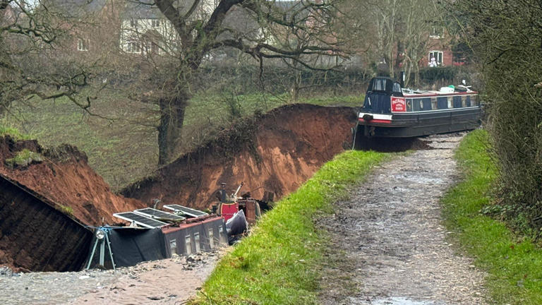 Stranded narrowboat pulled out of canal hole