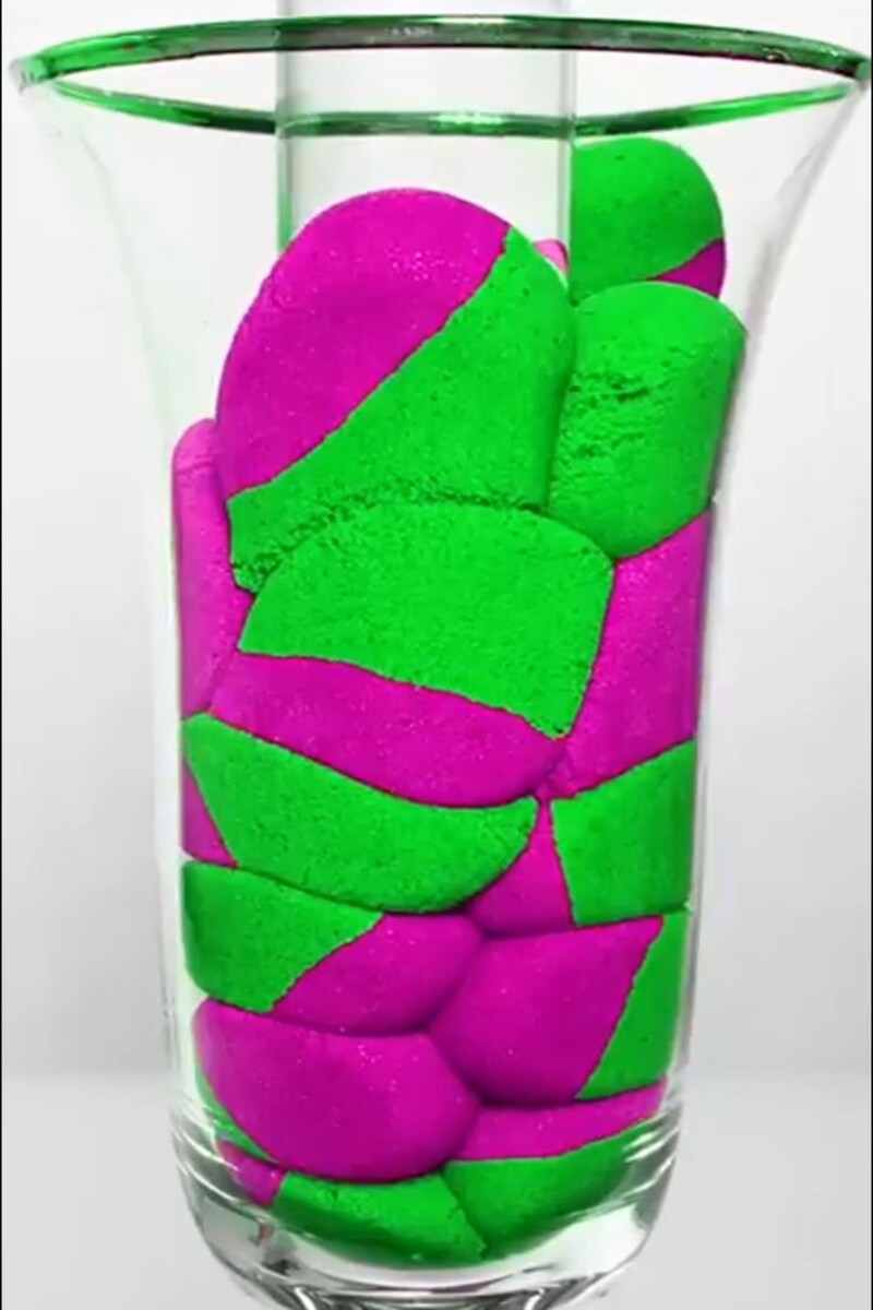 Colorful kinetic sand balls in glass