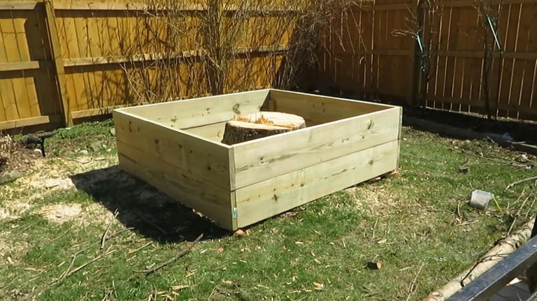 Hide the eyesore of an old tree stump with this raised garden bed idea