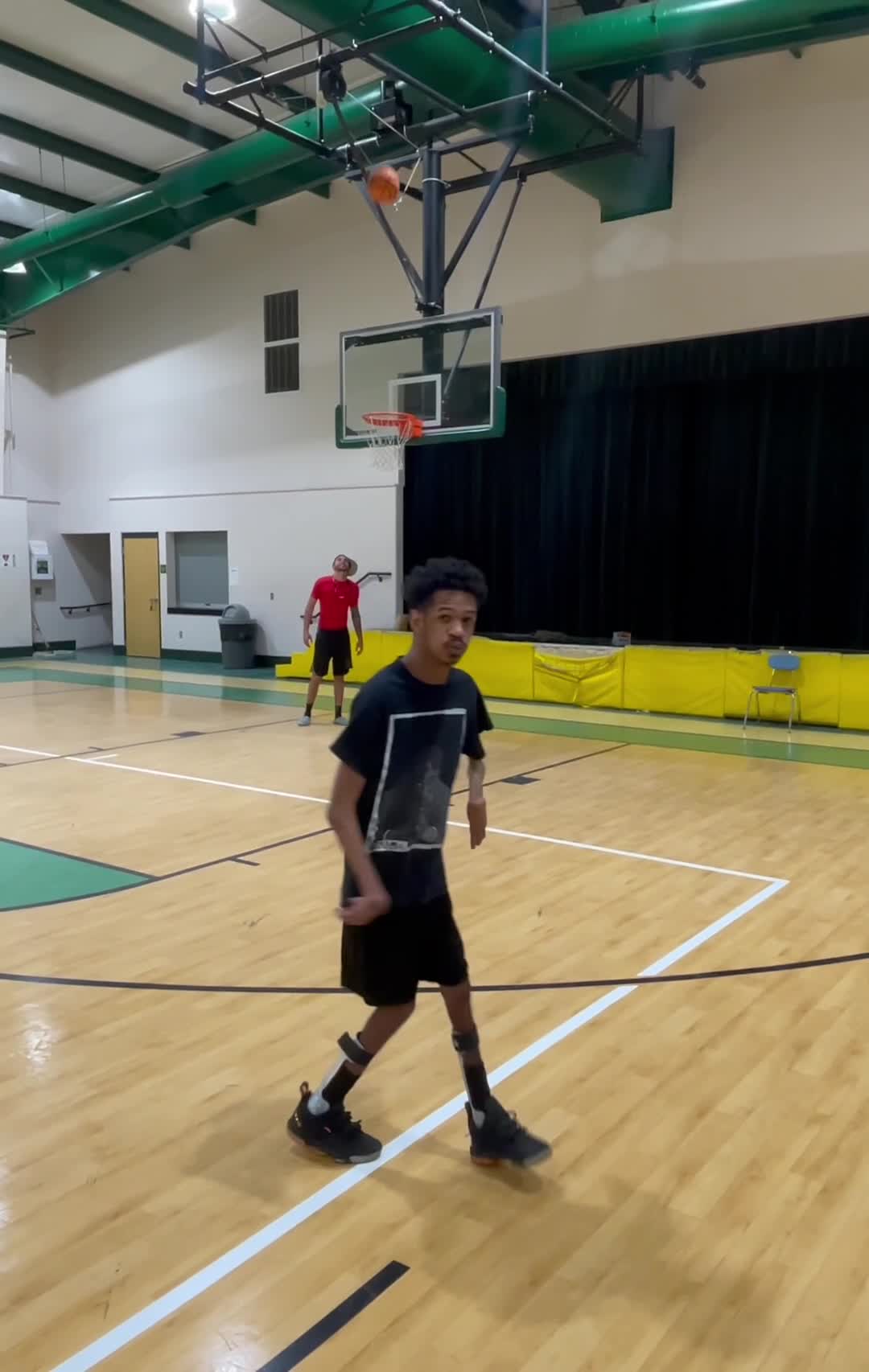 Young athlete with prosthetics practicing basketball on the court