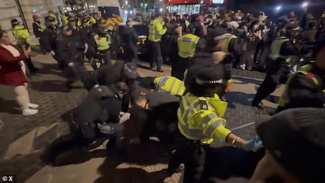 Moment baton-wielding police clash with protesters outside Iranian embassy