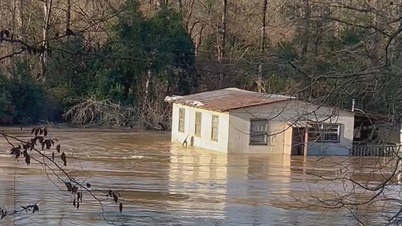 Floating house drifts past resident during Mississippi flooding