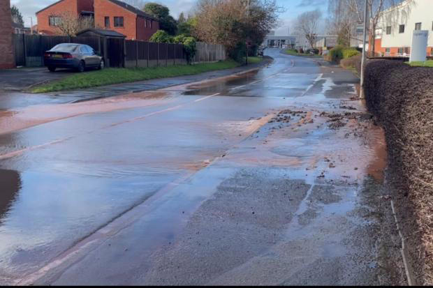 Burst water main causes flooding and delays on busy road
