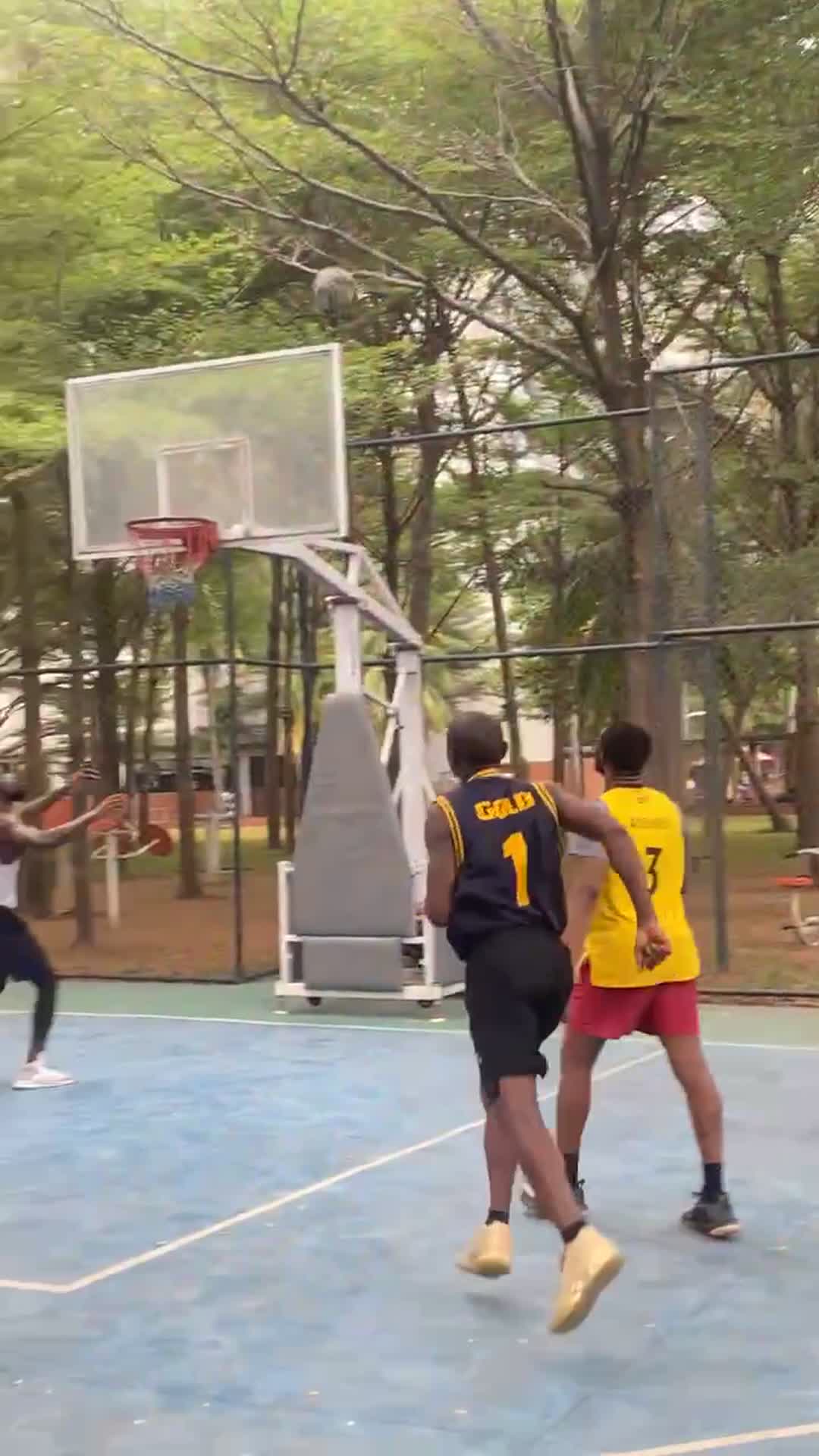 Friends play an intense basketball game on outdoor court