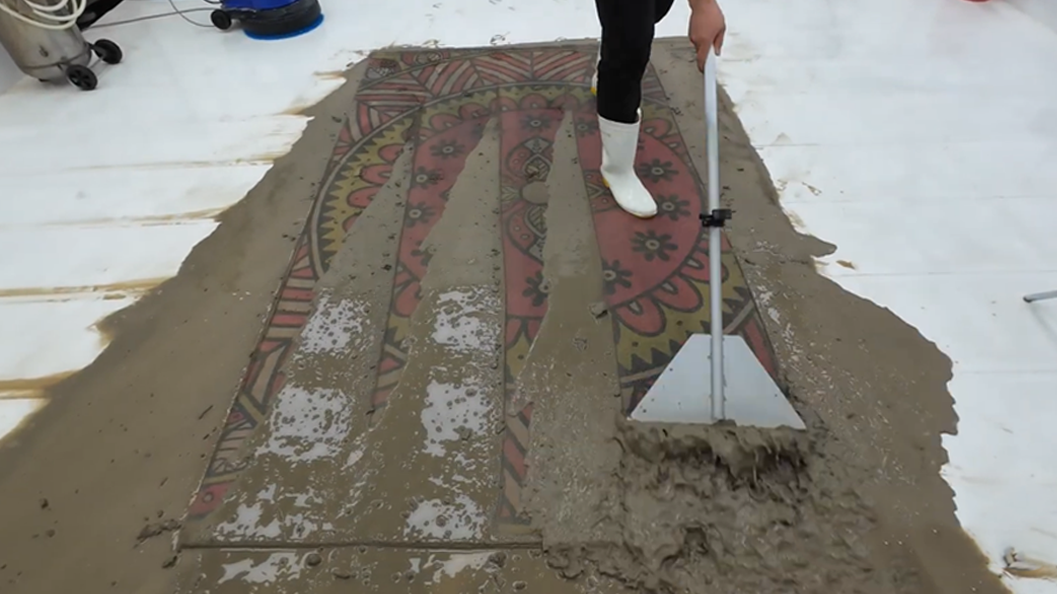 What pattern is revealed as the mud slides away?