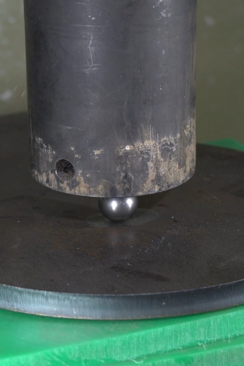 Nghiền nát một quả cầu thép dưới máy ép thủy lực