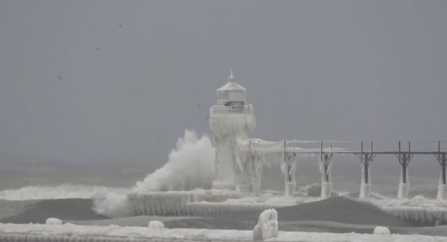 Powerful waves smash against frozen lighthouse on Lake Michigan