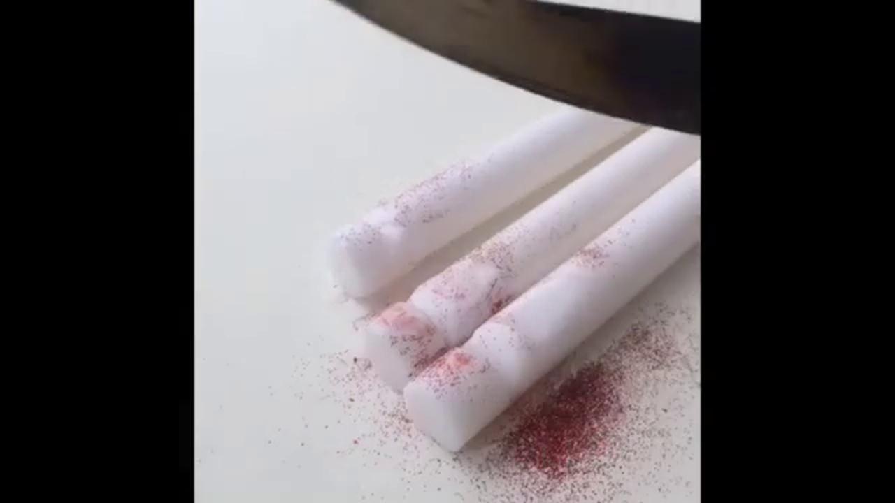 White candles with red glitter and hot knife cutting