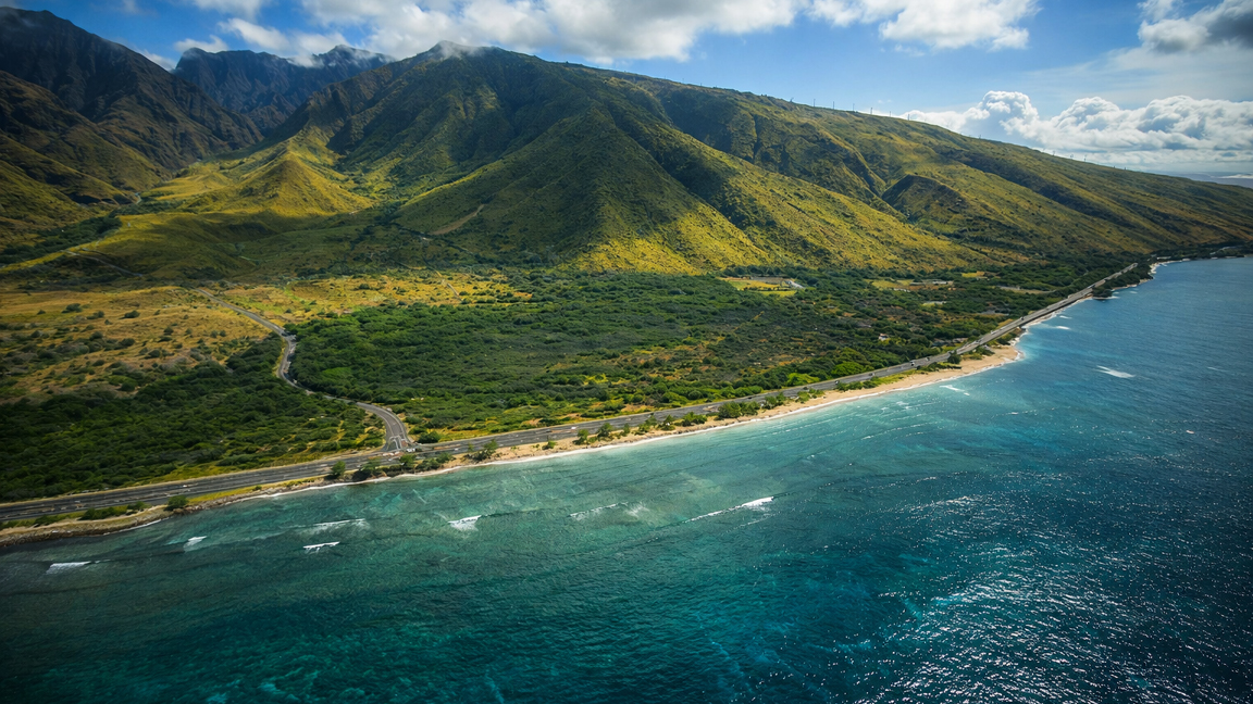 Coastal road by lush green mountains