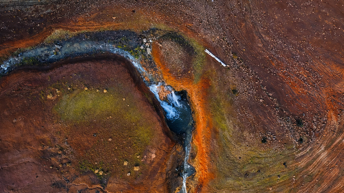Hot spring flowing through colorful earth