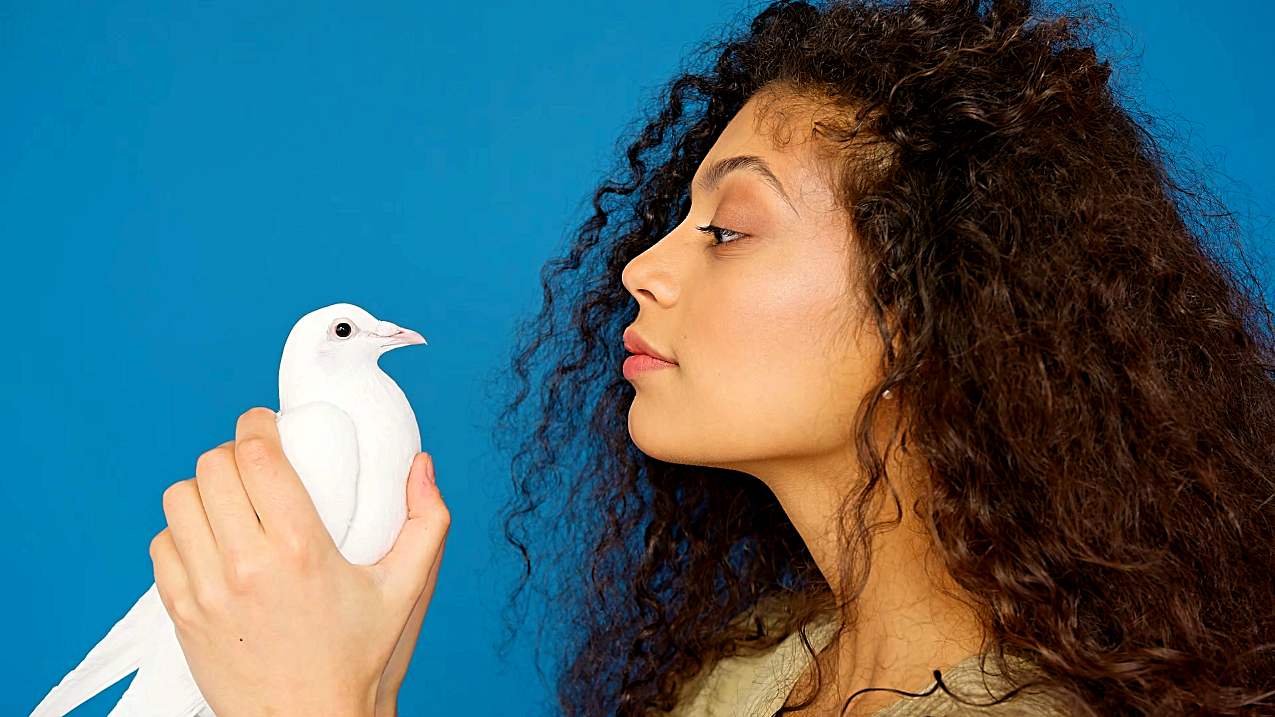 A girl is caught in a special moment with a pigeon