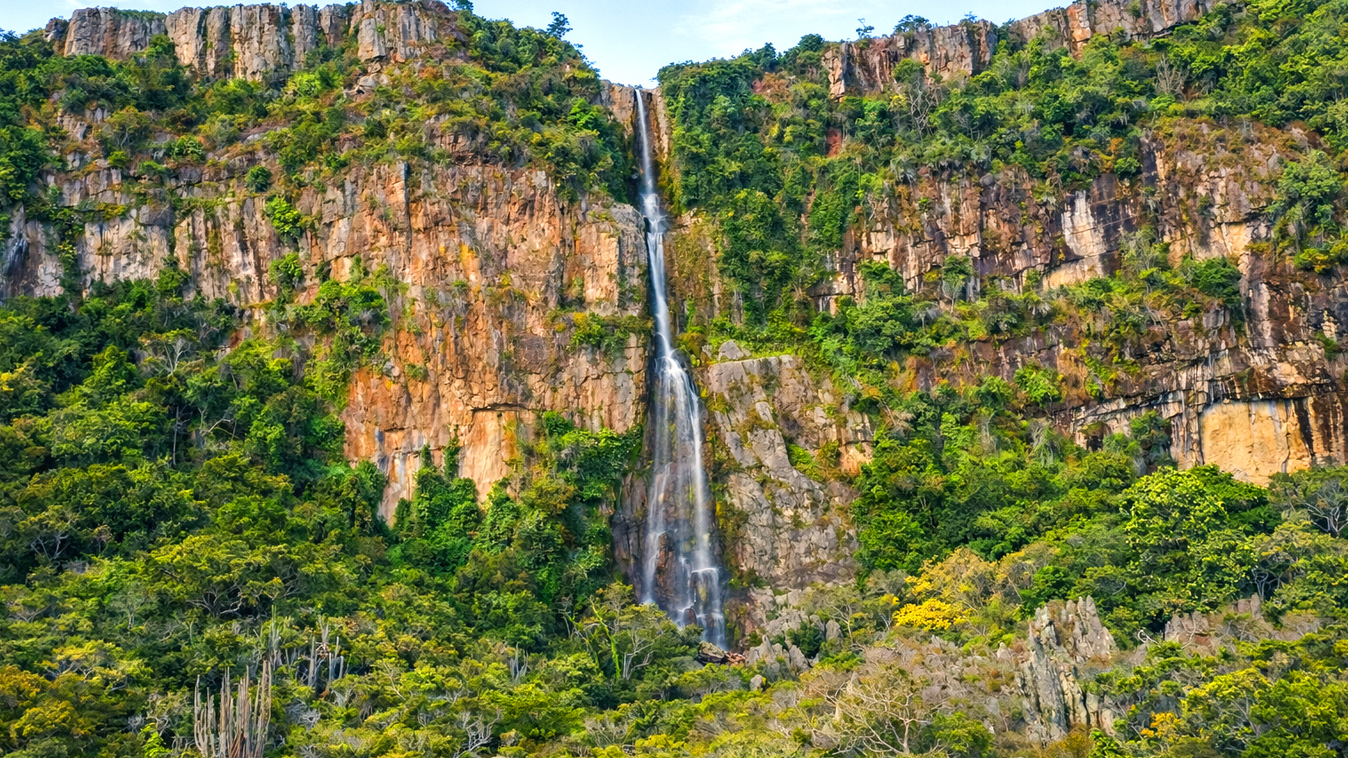 Cliffside waterfall in lush green valley